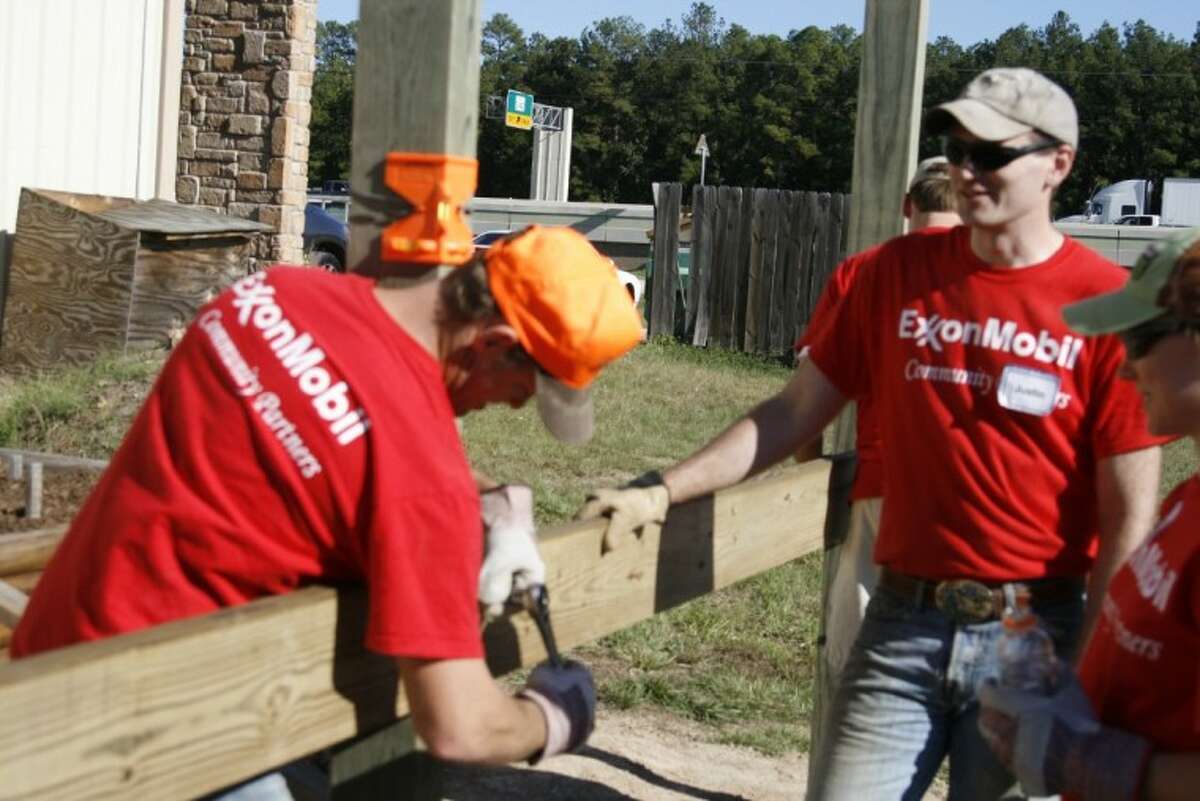 ExxonMobil volunteers work with New Horizons patrons to complete ...