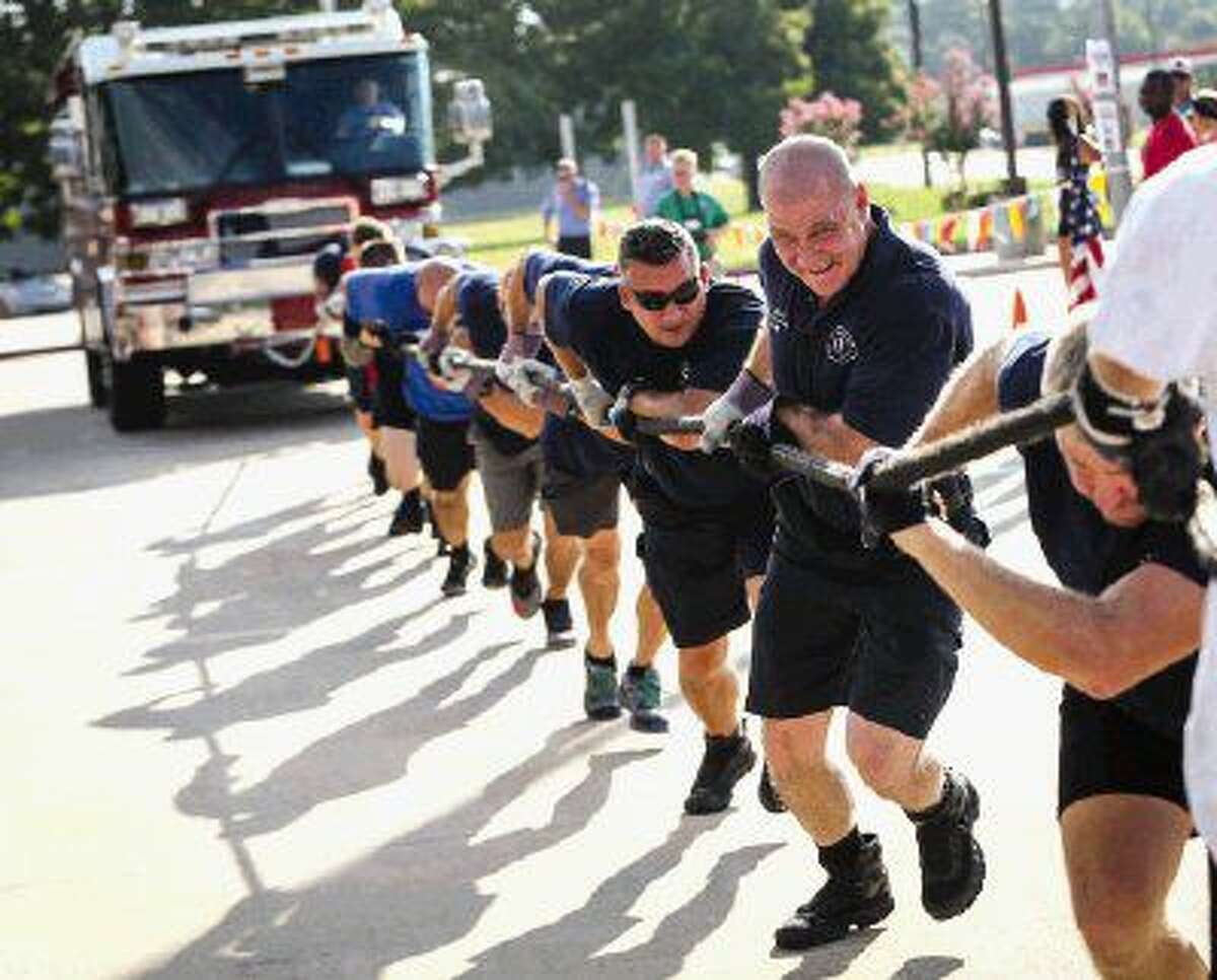 Firefighters, civilians pull fire truck for Special Olympic athletes