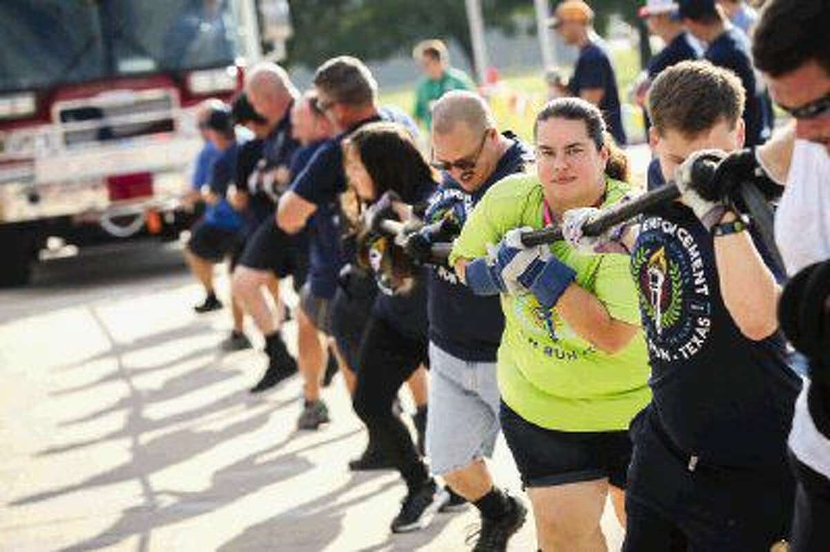 Firefighters, civilians pull fire truck for Special Olympic athletes