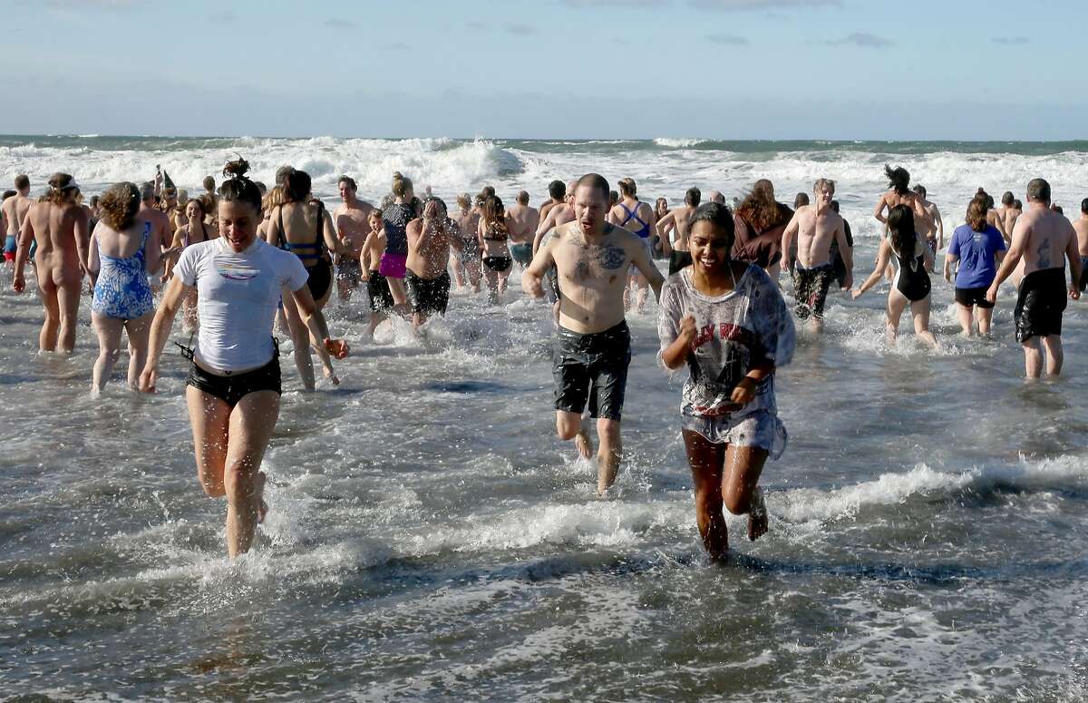 Scores brave frigid waters with New Year’s Day ocean swim