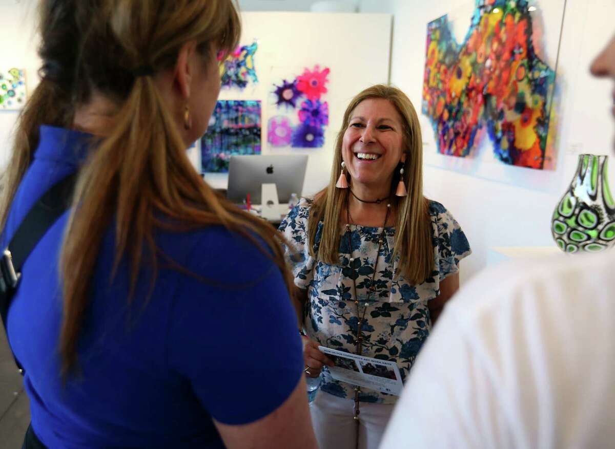 Artist Carol Simon creating flowery fence with recycled water bottles