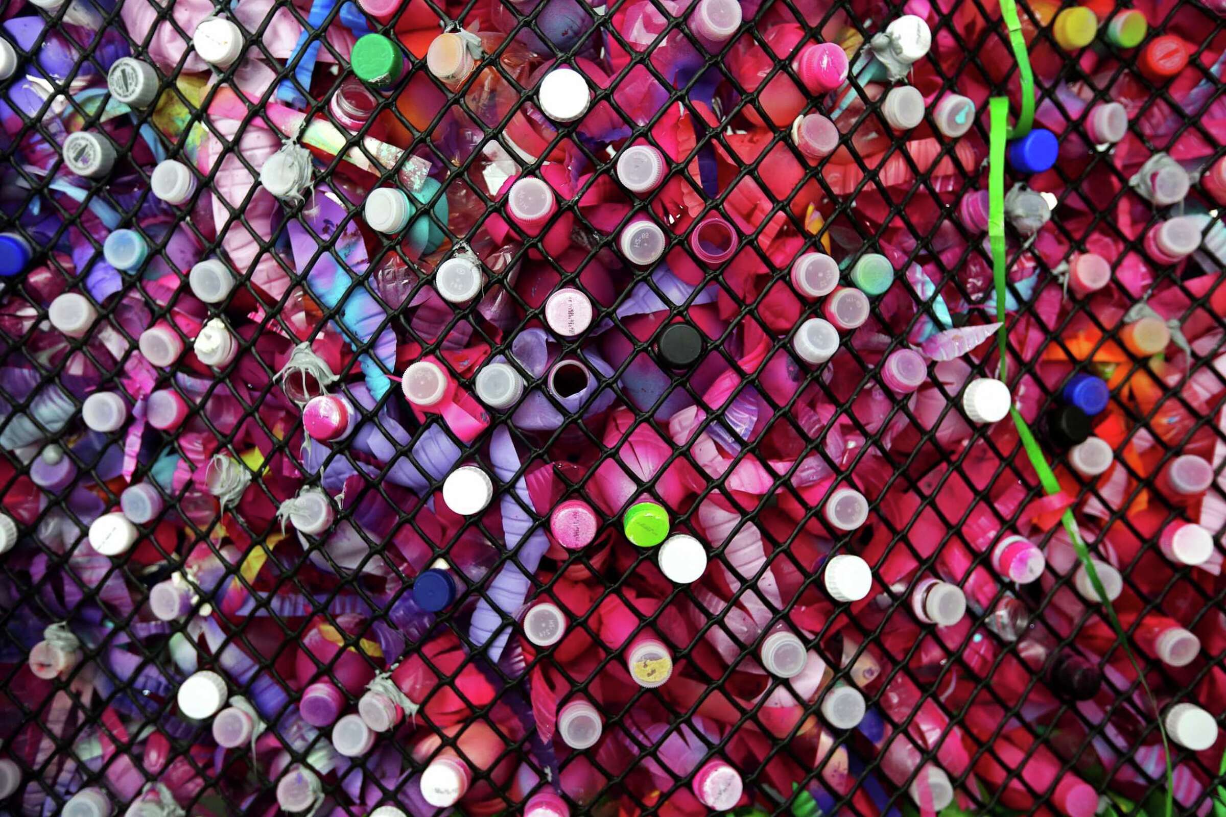 Artist Carol Simon creating flowery fence with recycled water bottles