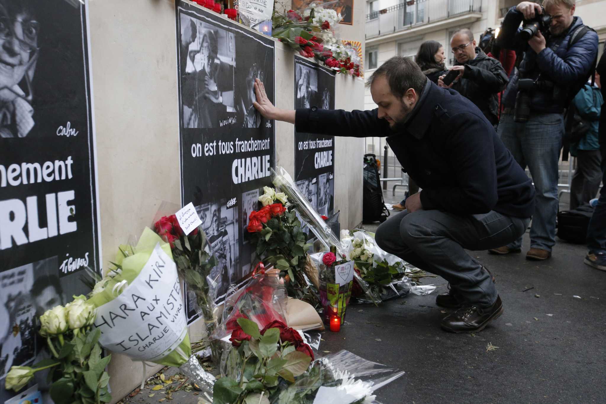 French police detain 9 in massive hunt for 2 suspects; Paris mourns victims