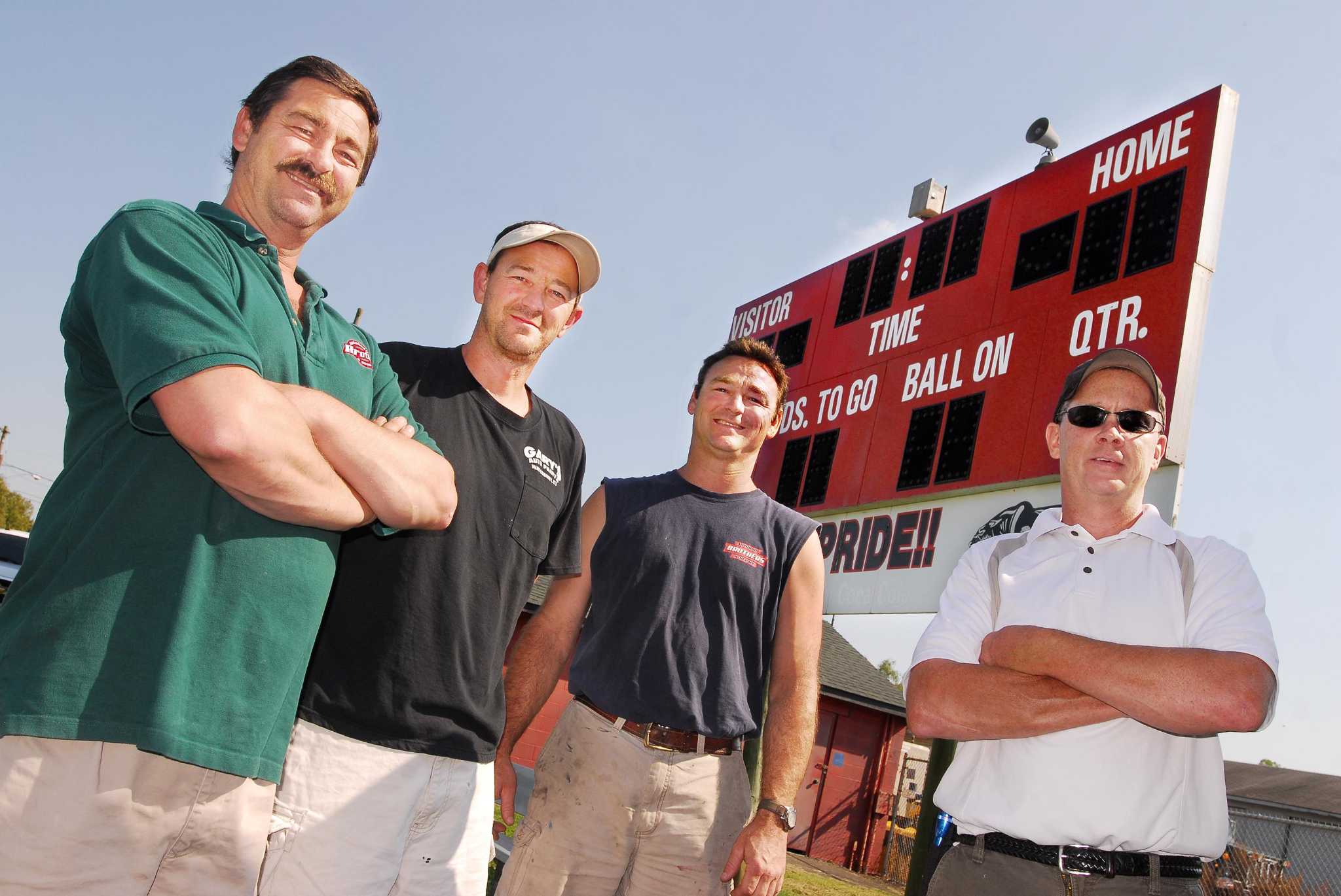 Volunteers pitch in to paint Cromwell scoreboard