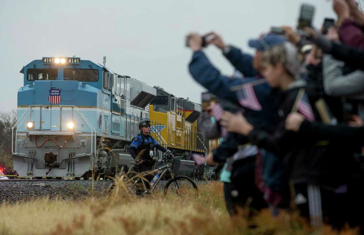 Thousands line train tracks to watch Bush funeral train to College Station